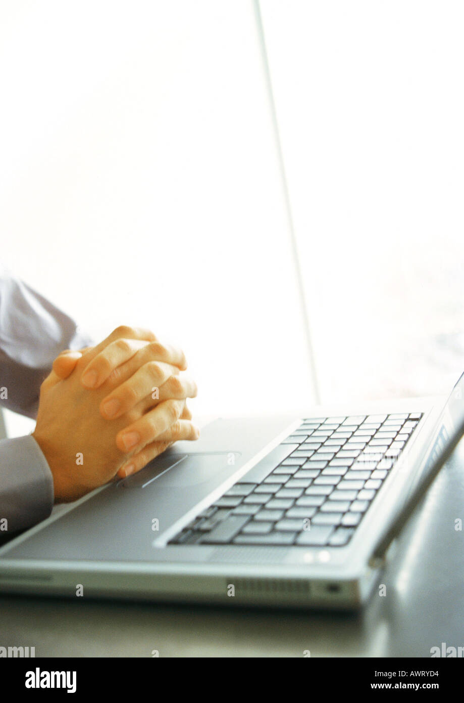 Businessman's folded hands on top of keyboard, close-up Stock Photo - Alamy