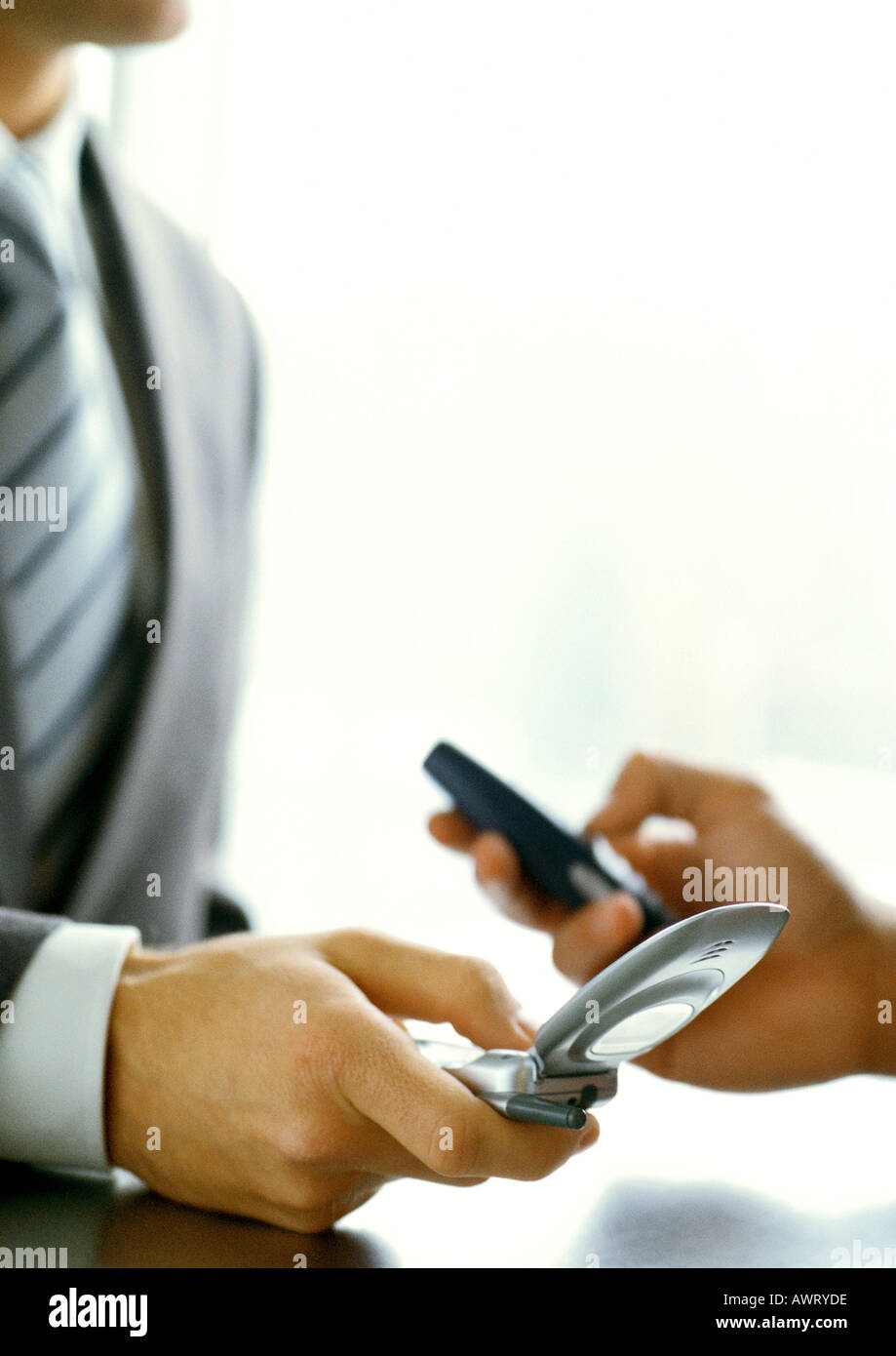 Business people's hands, exchanging numbers with cell phones, close-up ...
