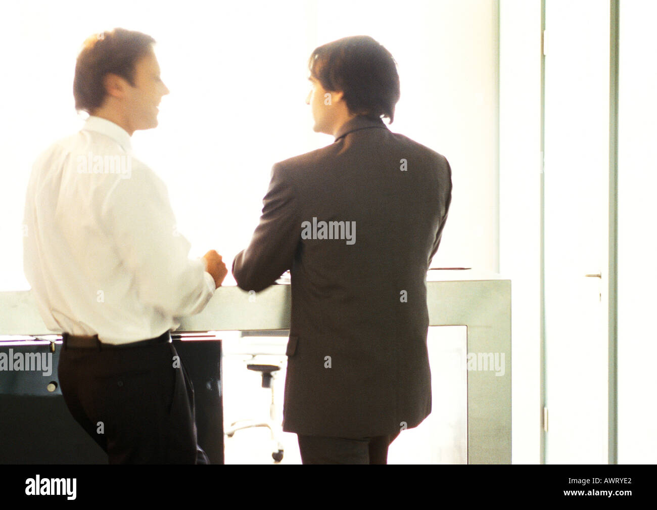 Businessmen standing, talking side by side Stock Photo - Alamy