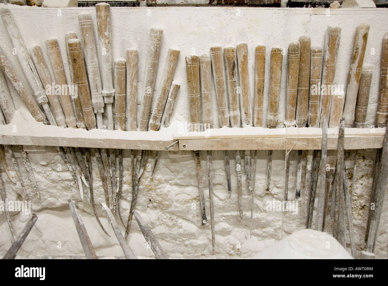 Alabaster sculptor's tools covered in white dust in the workshop ...