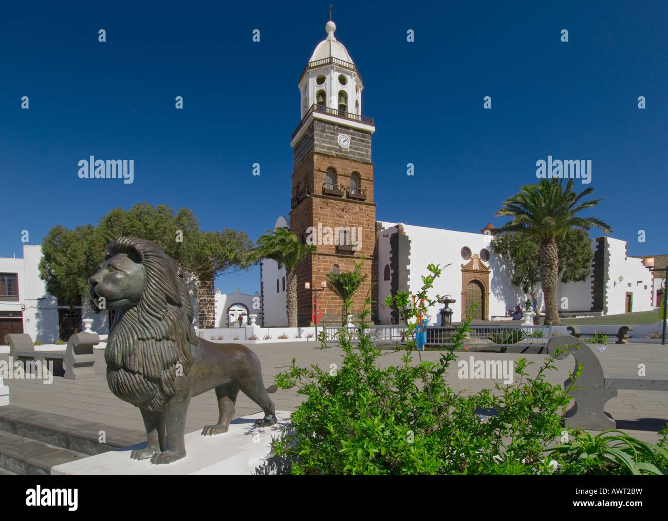 Teguise old town square with bronze lion sculpture. Medieval church of ...