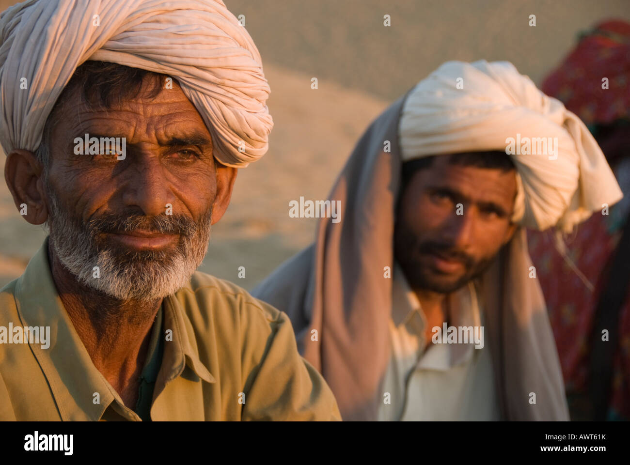 Portrait of two camel drivers dressed in turbans at sunset Stock Photo ...