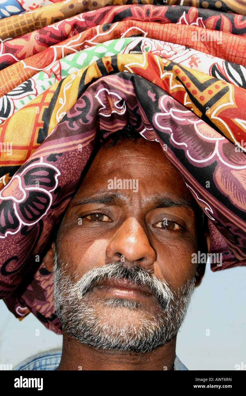 Indian man in Tamil Nadu selling material which he carries on his head ...