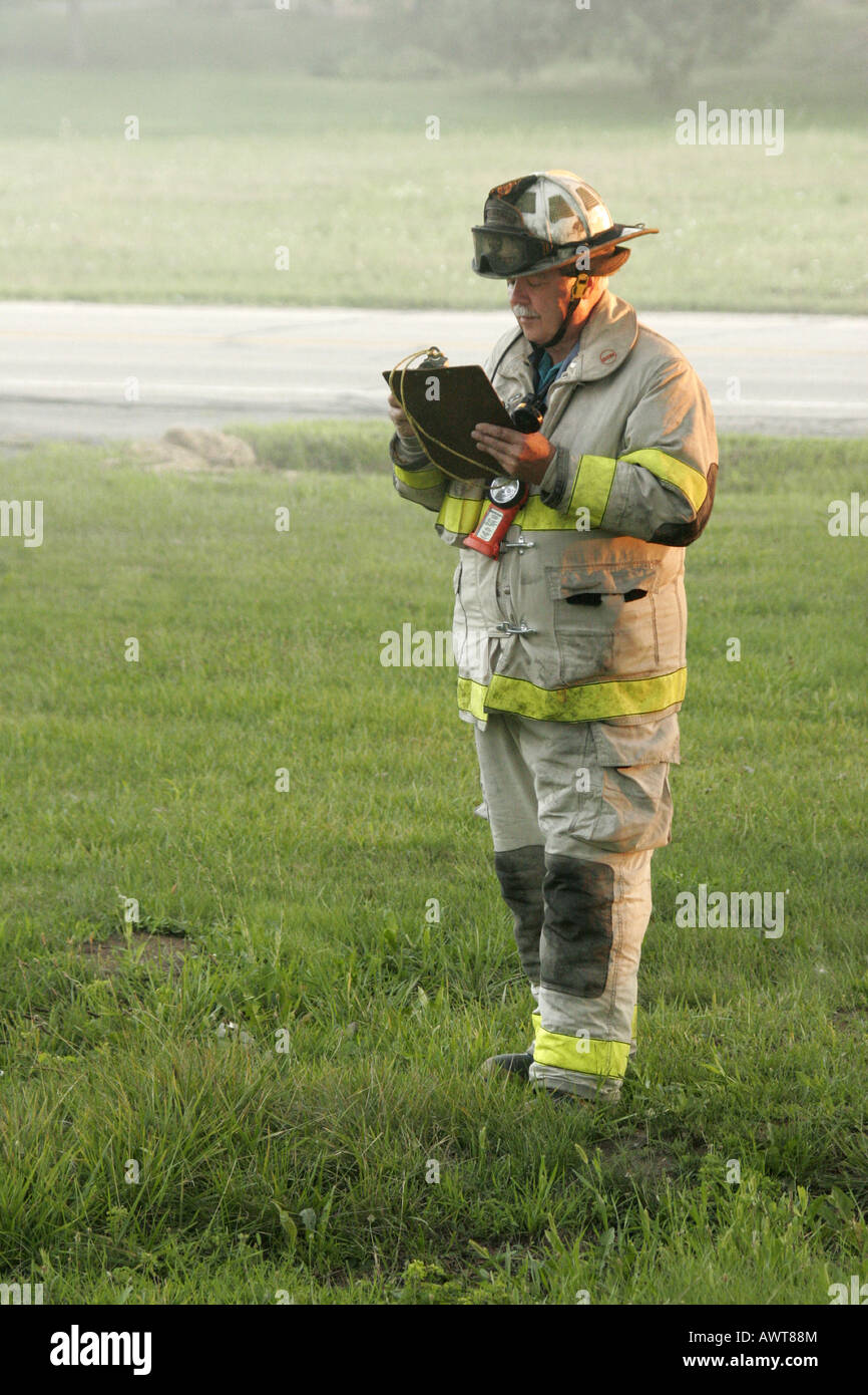 A firefighter recording information on a clipboard of the technical ...