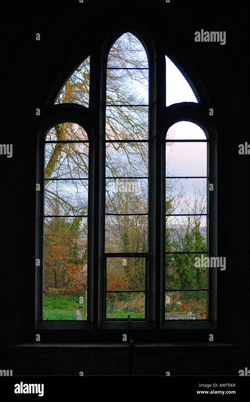 View through a glassless arched window of a derelict church burnt out ...