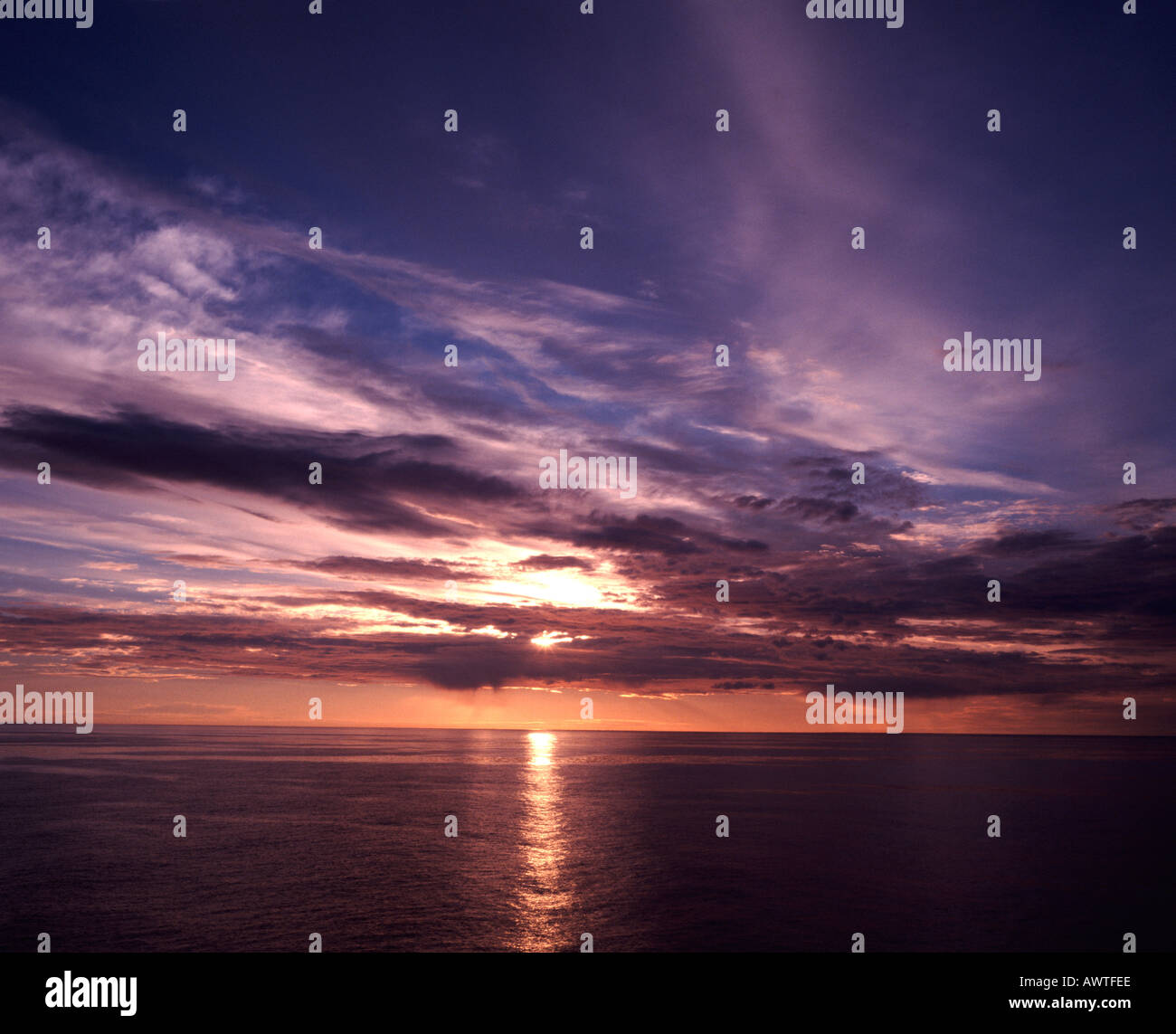 The midnight sun sitting above the horizon reflecting into the see off ...