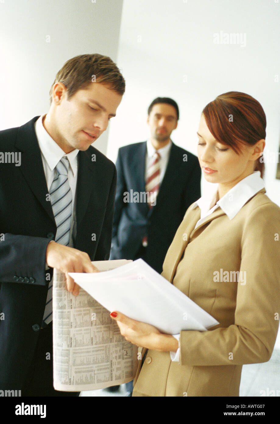 Two businessmen businesswoman examining document hi-res stock ...