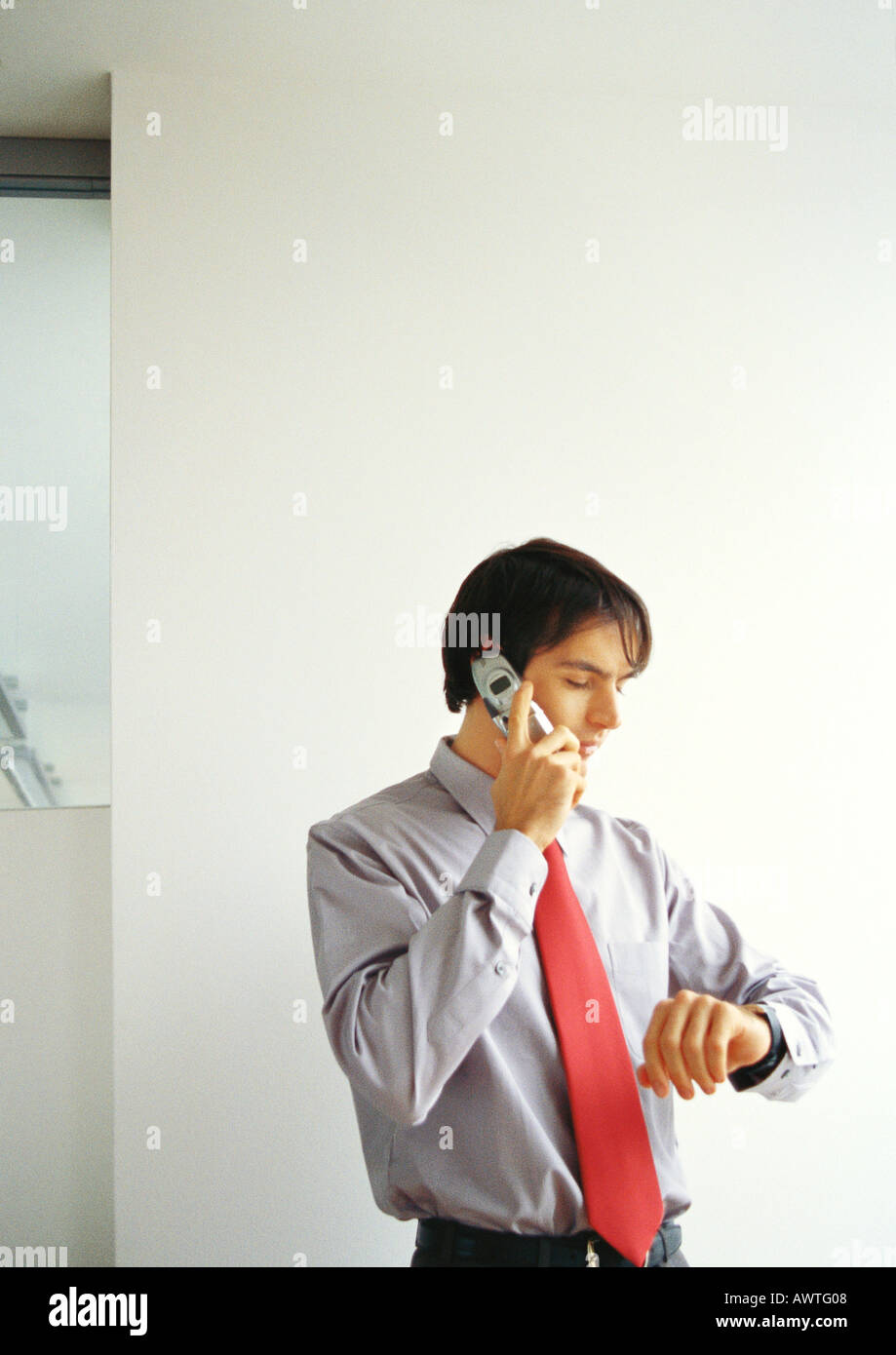 Businessman cell phone checking watch hi-res stock photography and ...
