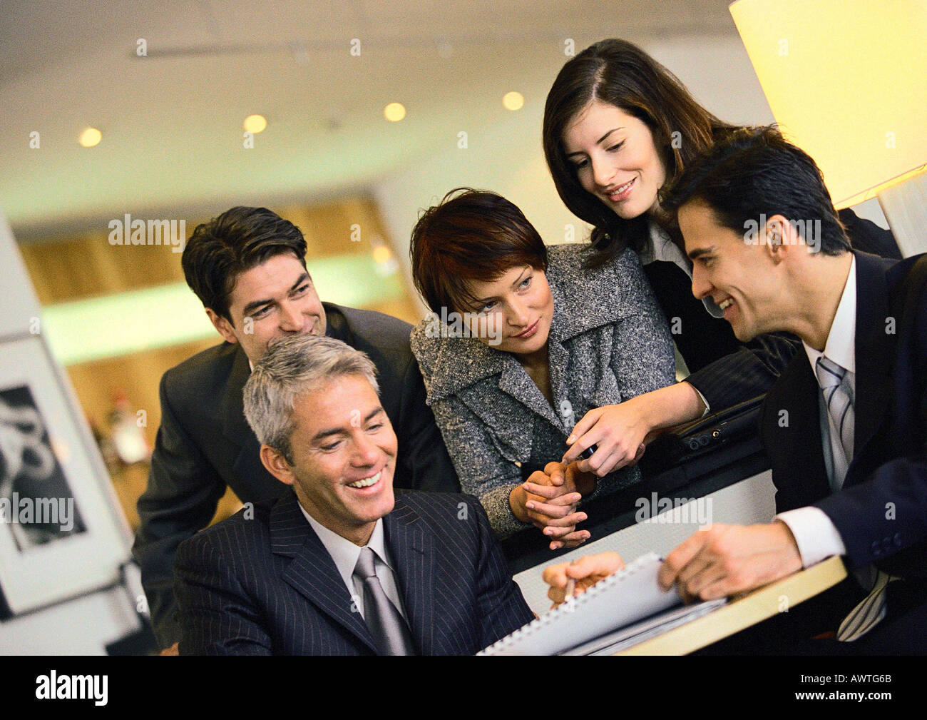 People grouped together, one man pointing at document Stock Photo - Alamy