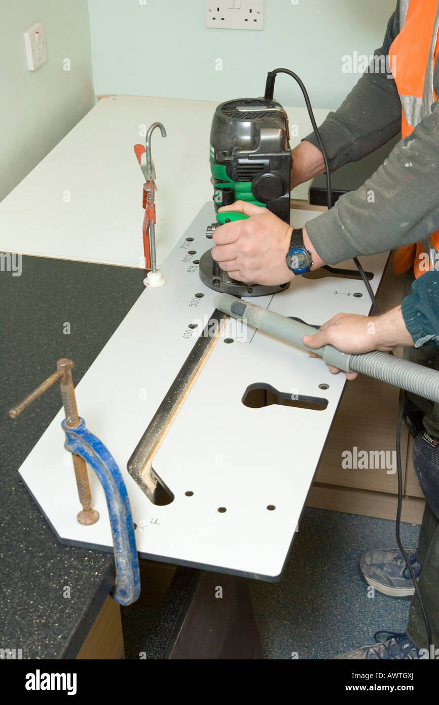 man using a router and jig plate to cut a worktop joint Stock Photo - Alamy
