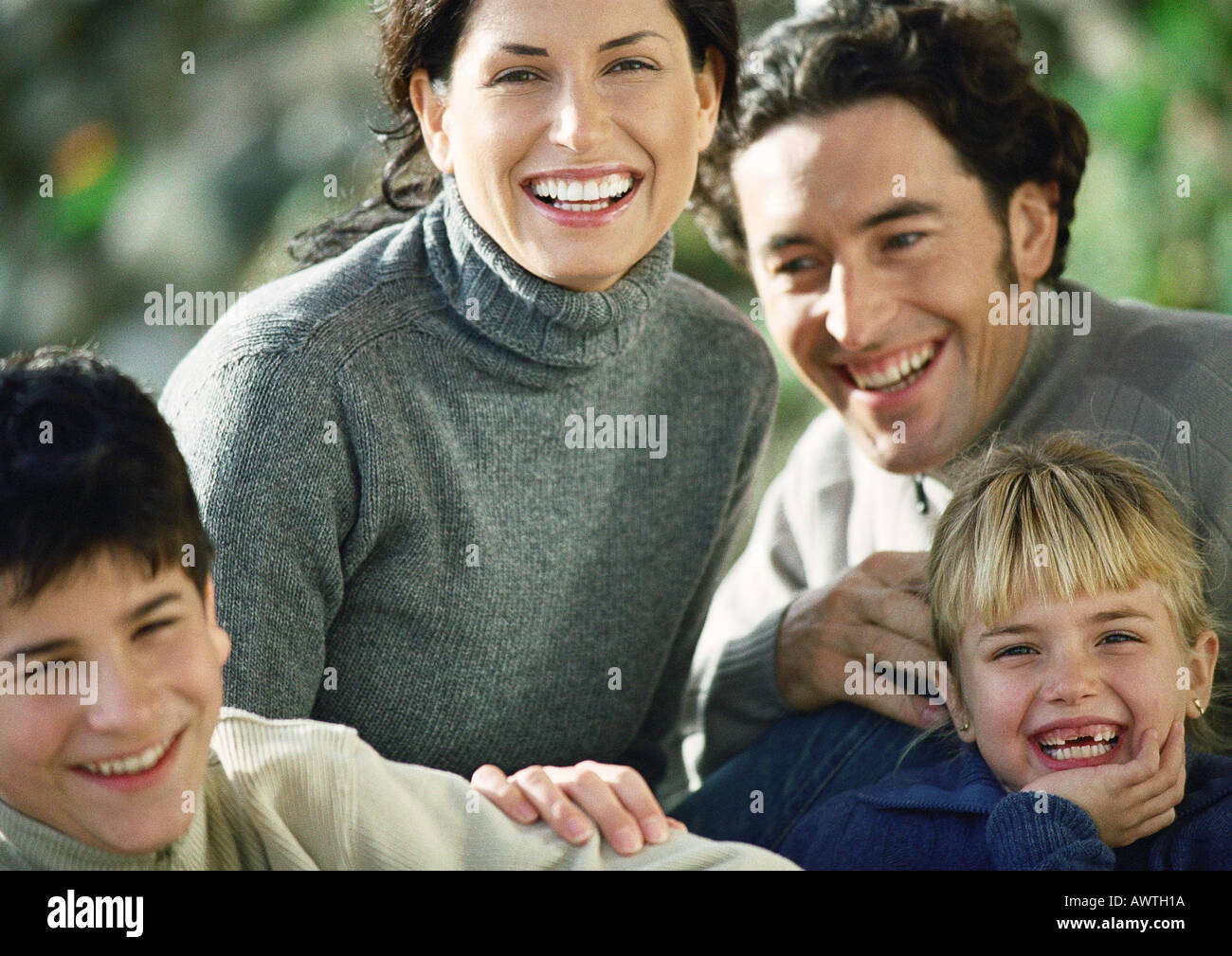 Adult man and woman with two children, head and shoulders, outside ...