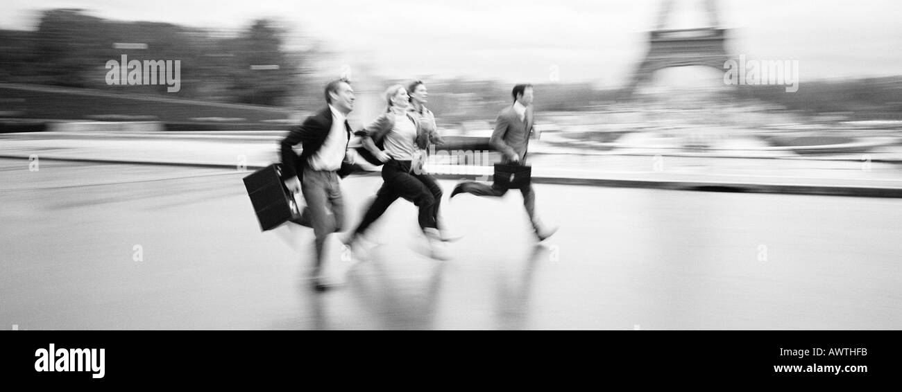 Business people running across esplanade in front of Eiffel Tower, b&w ...