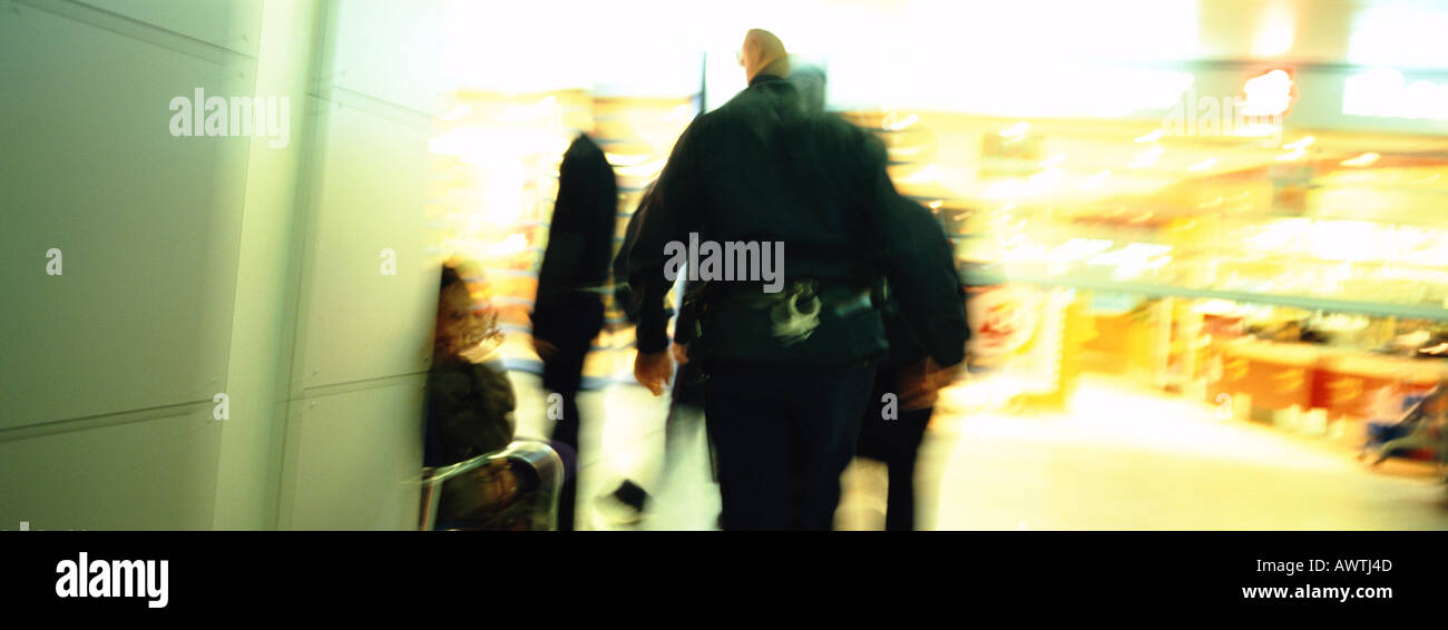 Police officer coming from hall going into shopping center, blurred ...