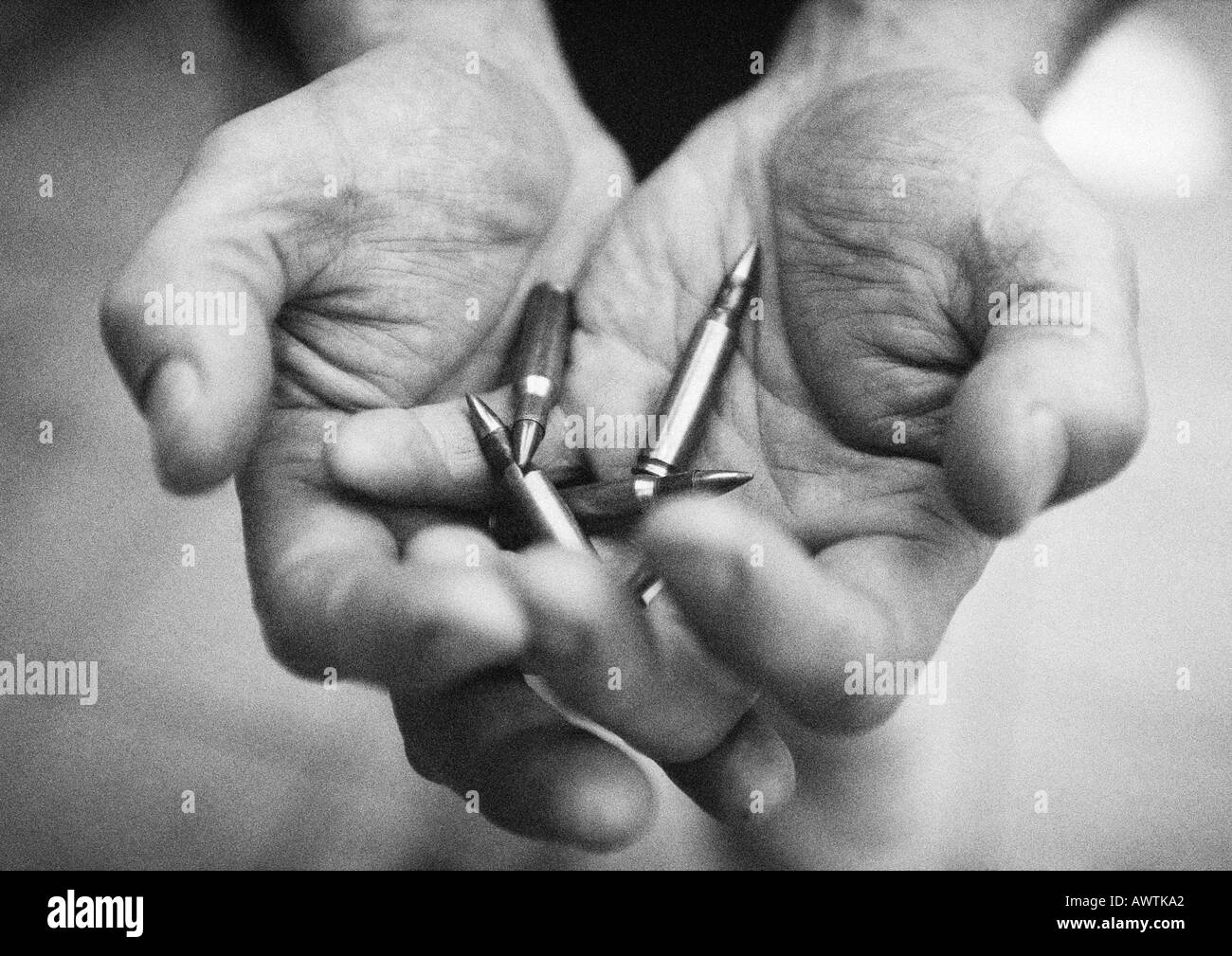 Hands holding bullets, close-up, b&w Stock Photo - Alamy
