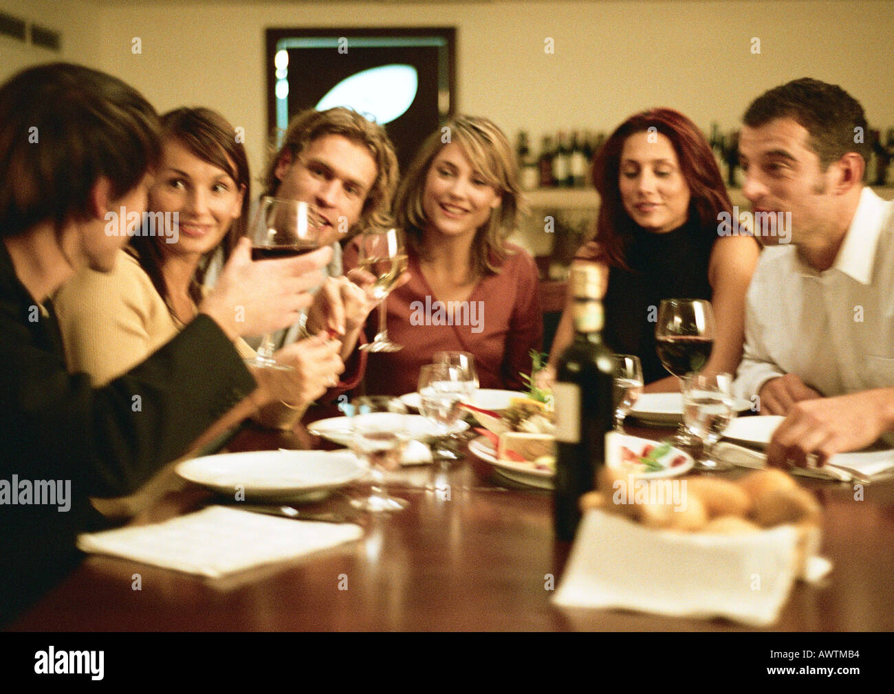 Group of young people sitting at table, having dinner together Stock ...