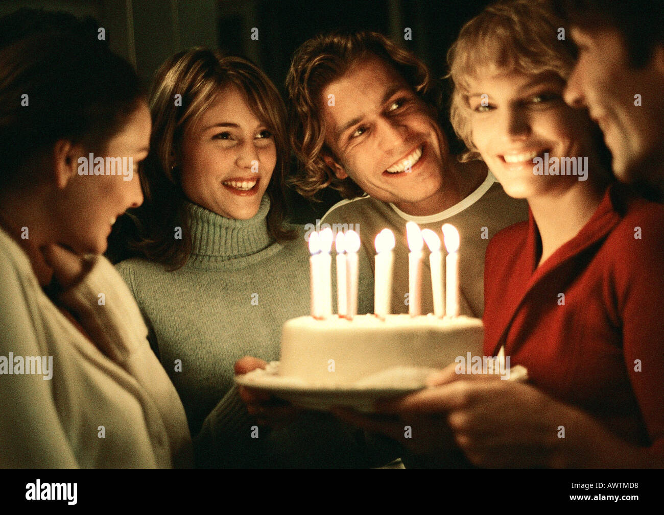 Woman holding birthday cake in group Stock Photo - Alamy