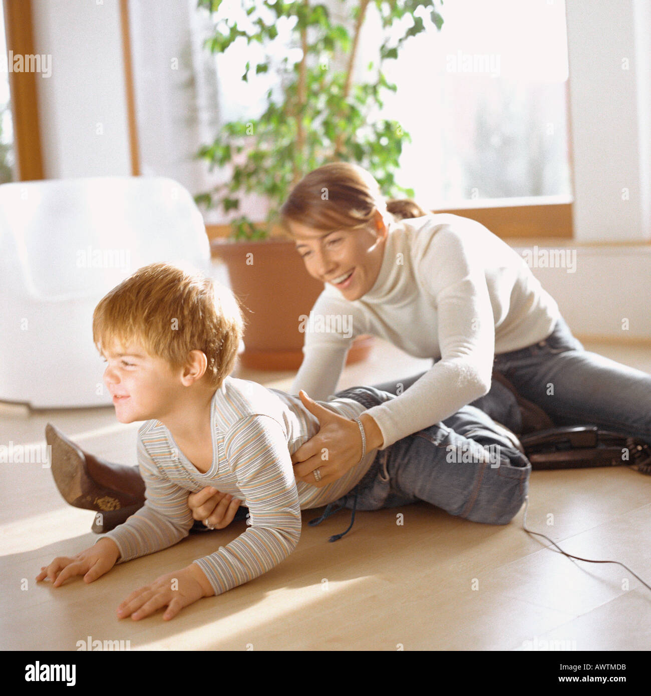 Mother grasping son, on floor Stock Photo - Alamy