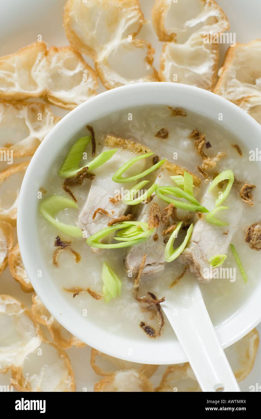 Congee, chinese rice porridge in a bowl surrounded by yu tiao, bread or ...