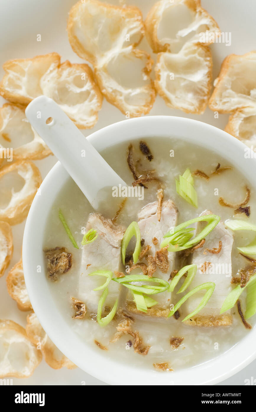 Congee, chinese rice porridge in a bowl surrounded by yu tiao, bread or ...