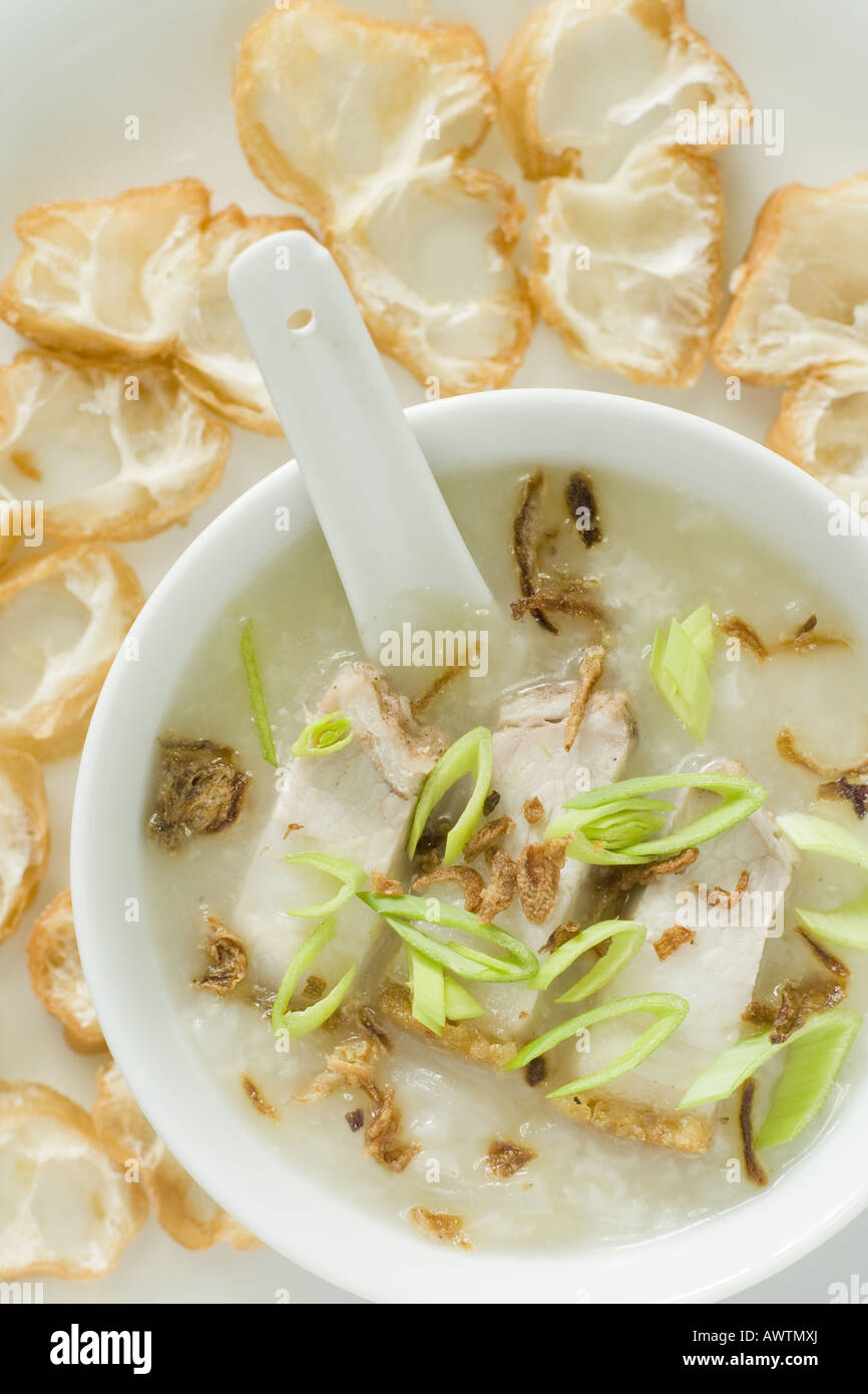 Congee, chinese rice porridge in a bowl surrounded by yu tiao, bread or ...