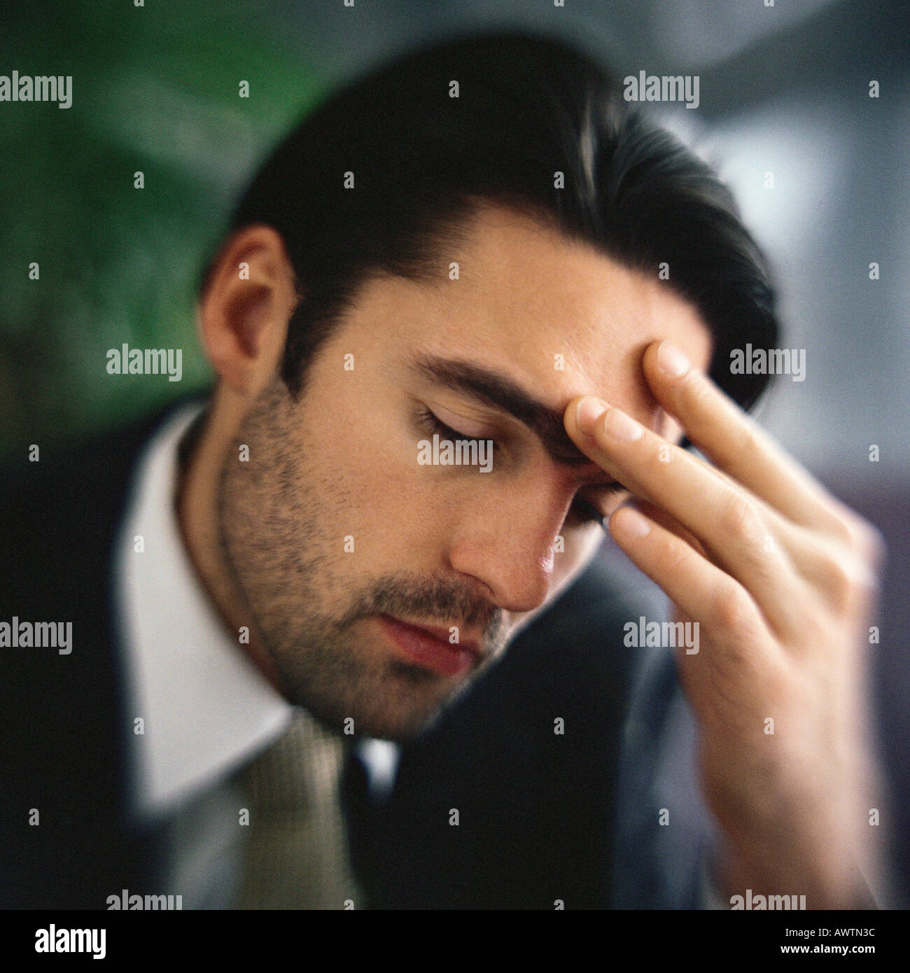 Businessman touching forehead with fingers, portrait Stock Photo - Alamy