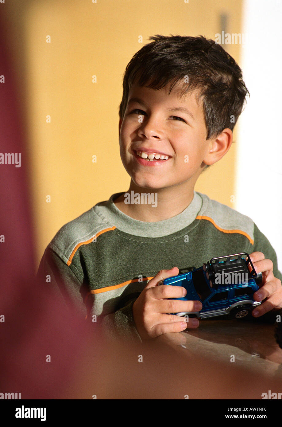 Child holding toy car, looking up Stock Photo - Alamy