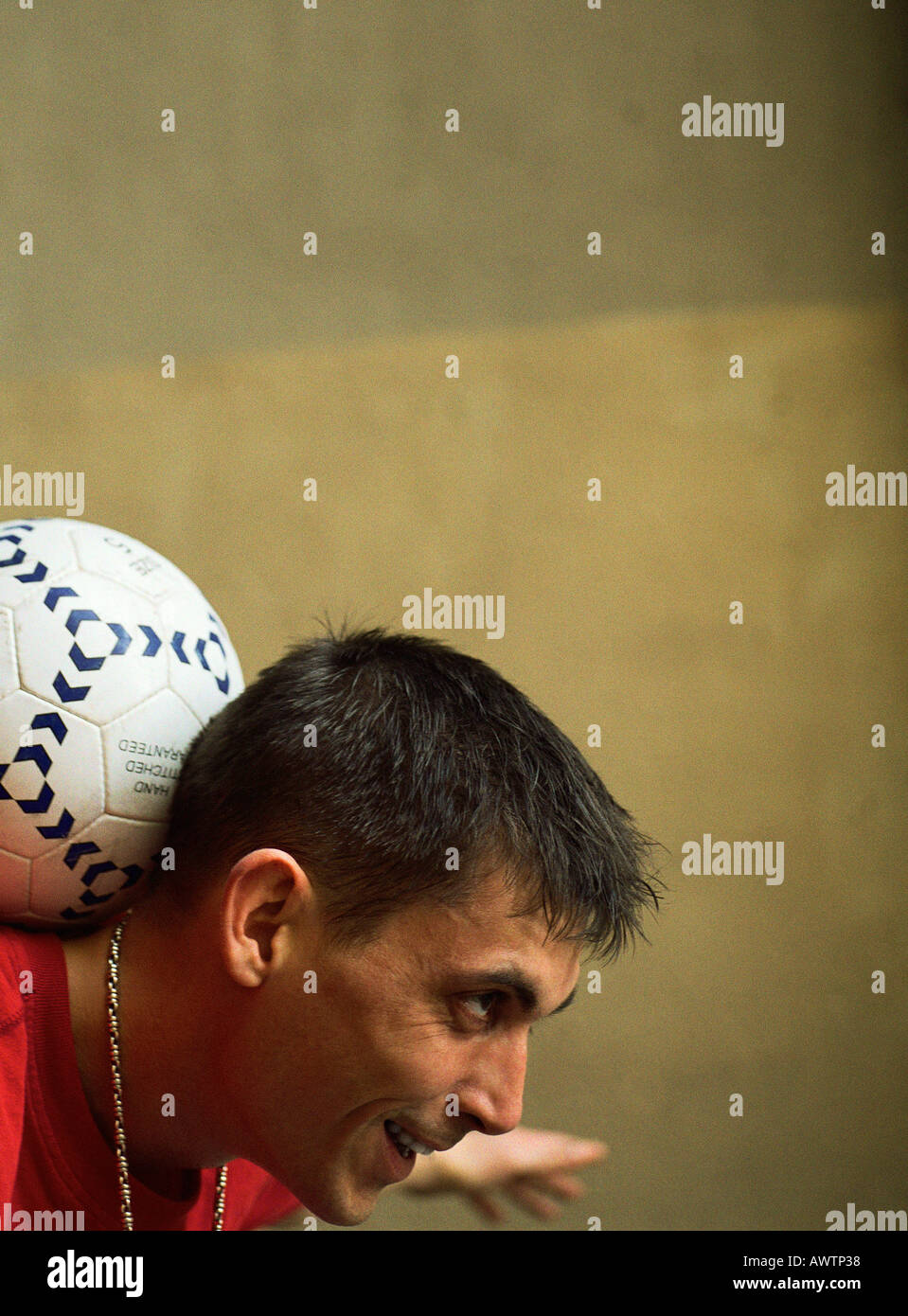 Profile of man balancing soccer ball on back of neck Stock Photo - Alamy