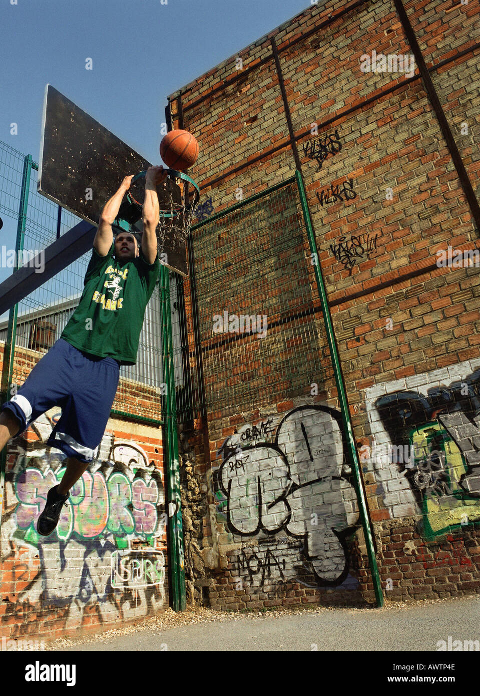 Man dunking basketball backwards in urban playground Stock Photo - Alamy