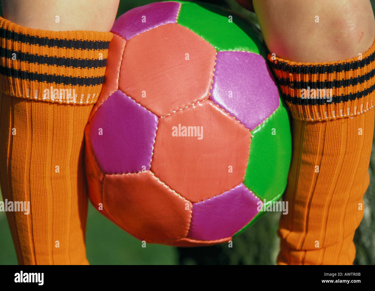 Colorful soccor ball between child's legs, close up Stock Photo - Alamy
