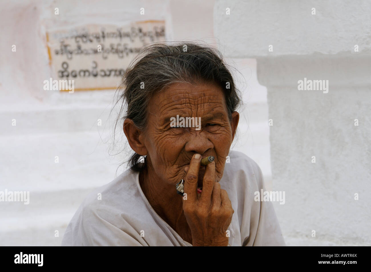 Old Woman at Shwezigon Pagoda smoking local cigar Stock Photo - Alamy