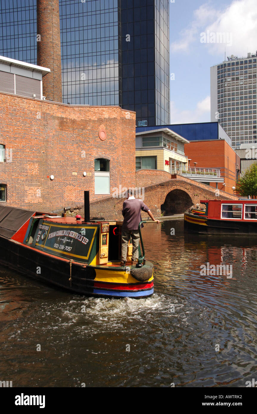 Man steering canal narrow boat on Birmingham Canal at Brindley Place ...