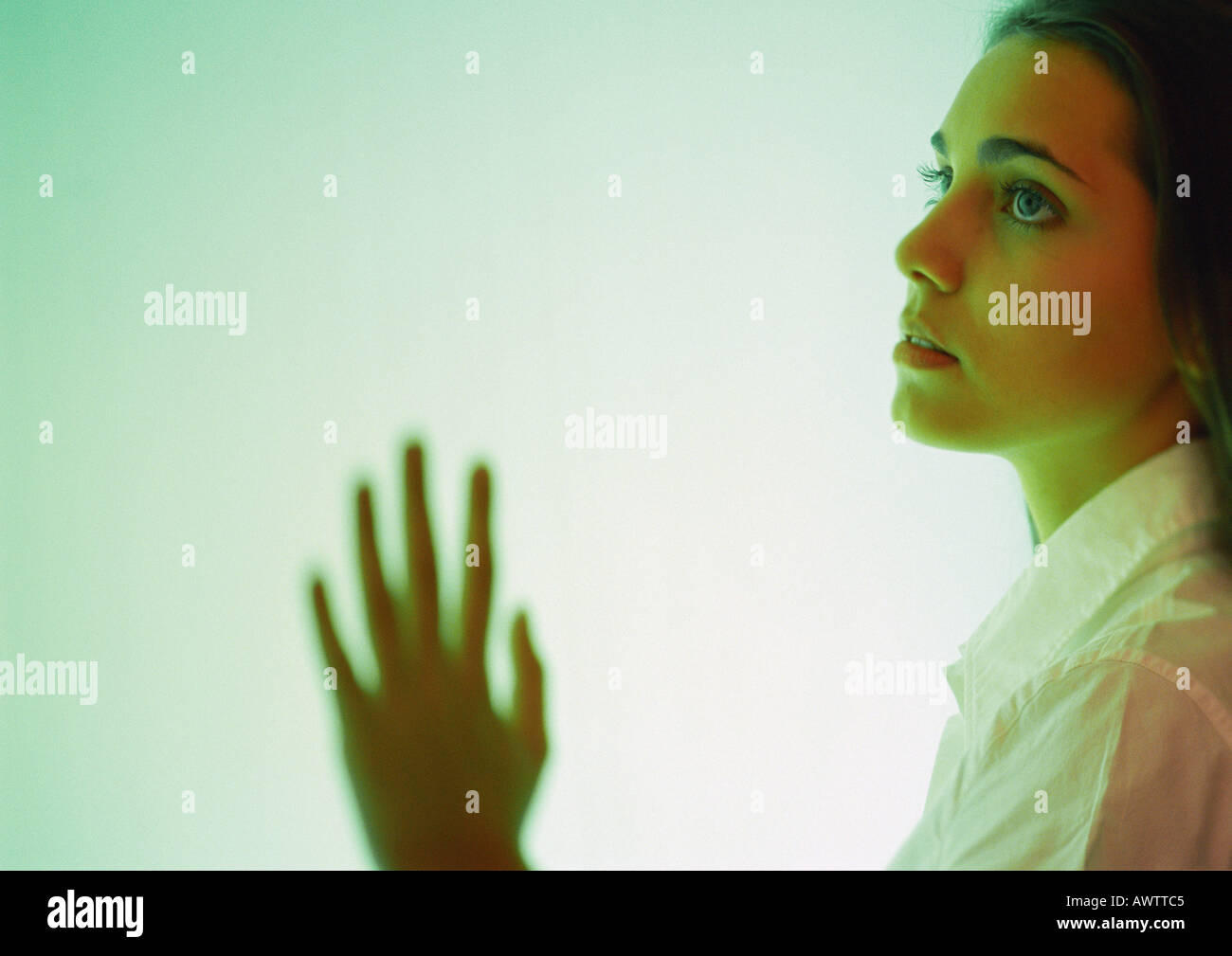 Woman with hand against wall, looking up Stock Photo - Alamy