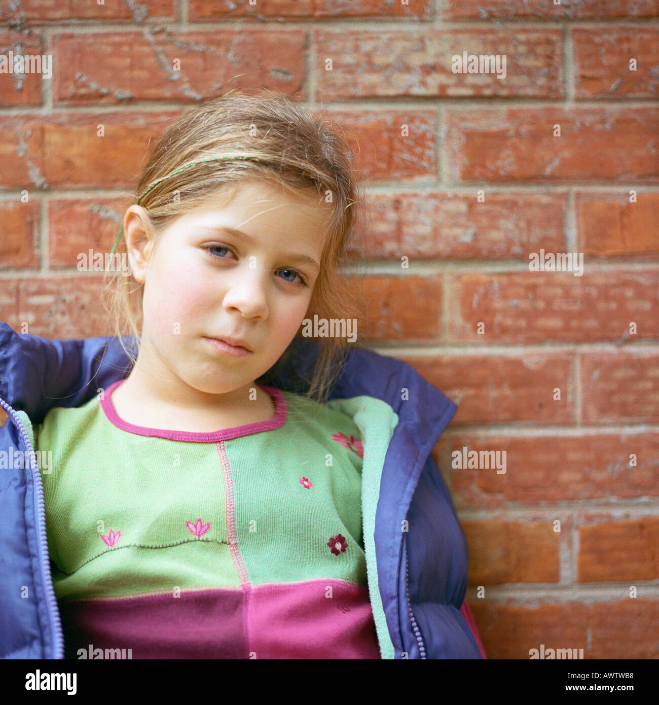 Girl leaning against brick wall, portrait Stock Photo - Alamy