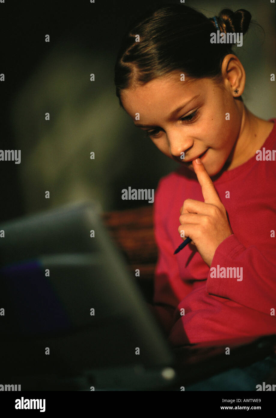 Young girl looking down at computer, close up Stock Photo - Alamy