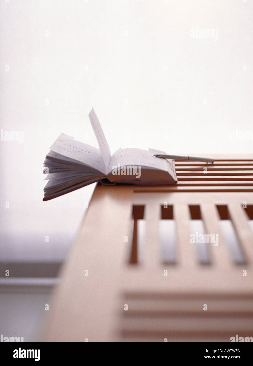 Open book hanging off wooden table Stock Photo - Alamy