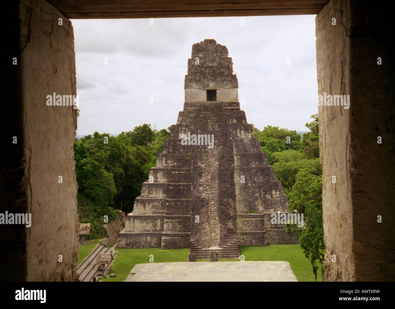Panoramic view imposing Maya stone pyramid through entry door at top ...