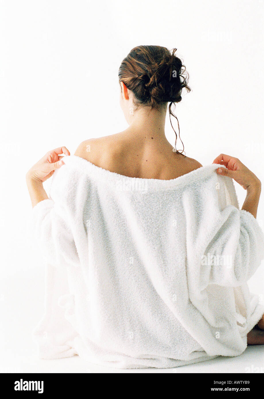 Woman sitting on floor , robe partially removed revealing shoulders ...