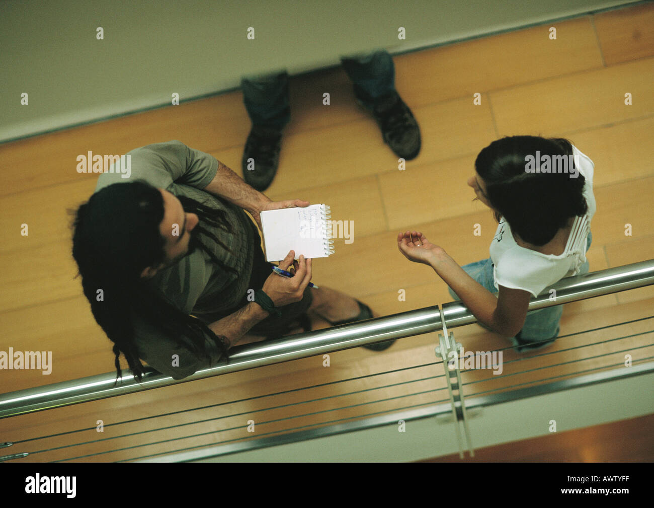 Man and woman leaning against rail, talking, view from above Stock ...