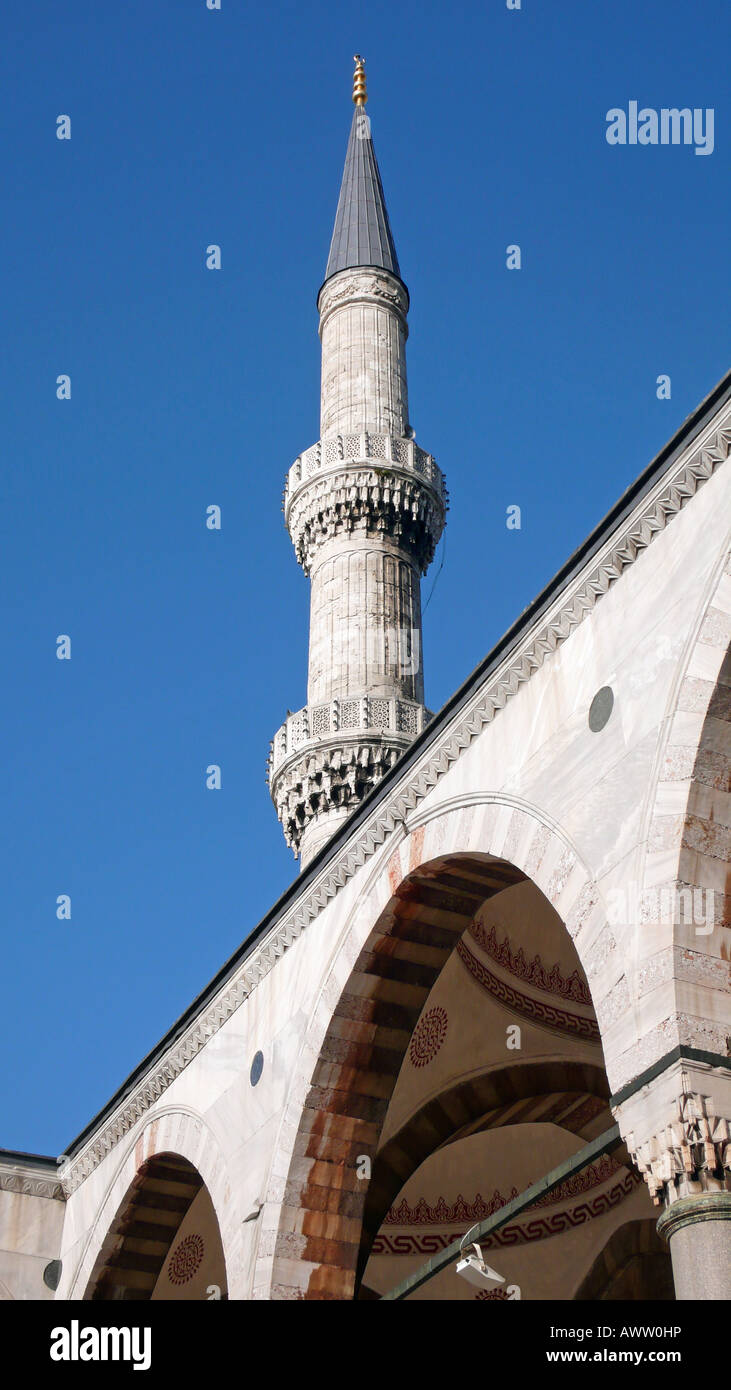 A pencil-shaped minaret towers over an archway at the Blue Mosque ...