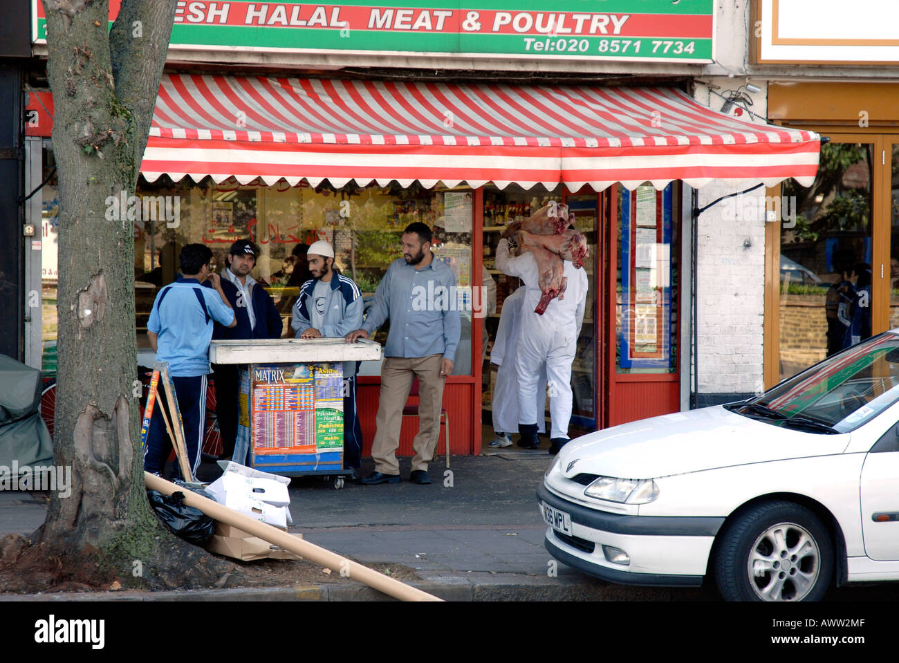 Street scene of people outside a Halal butcher shop in Southall ...