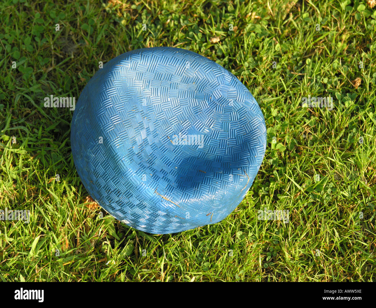 Deflated blue ball on grass. Can be a metaphor for depression or ...