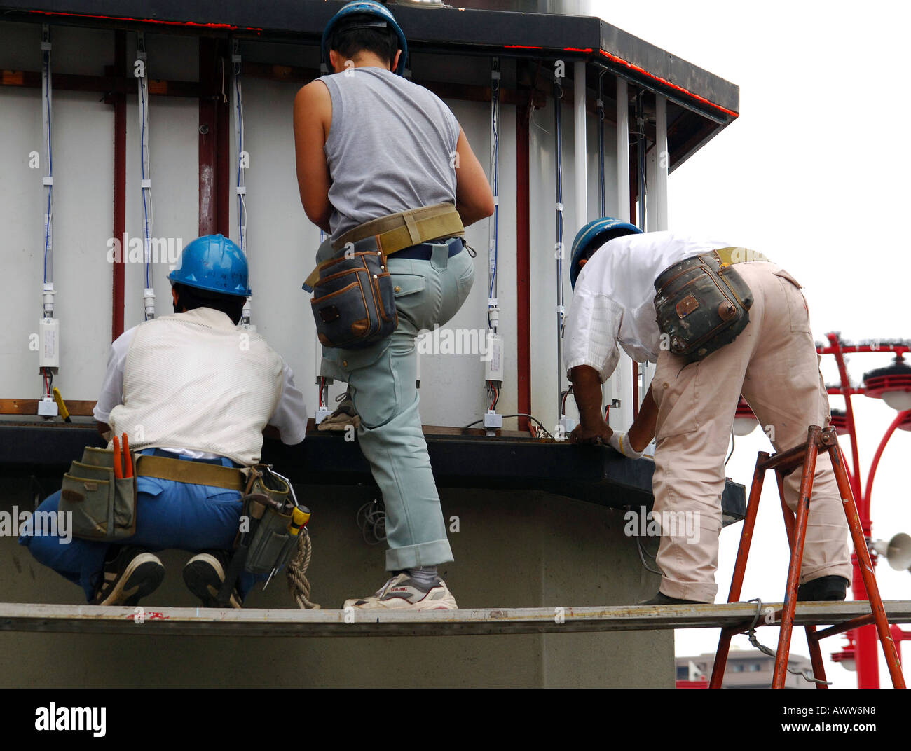Building workers constructing an electronic neon sign, Tokyo Japan ...