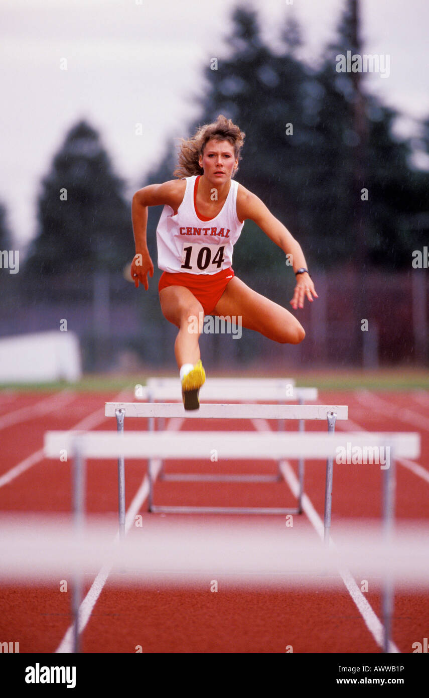 A woman hurdler leaps over a barrier in a training run Stock Photo - Alamy