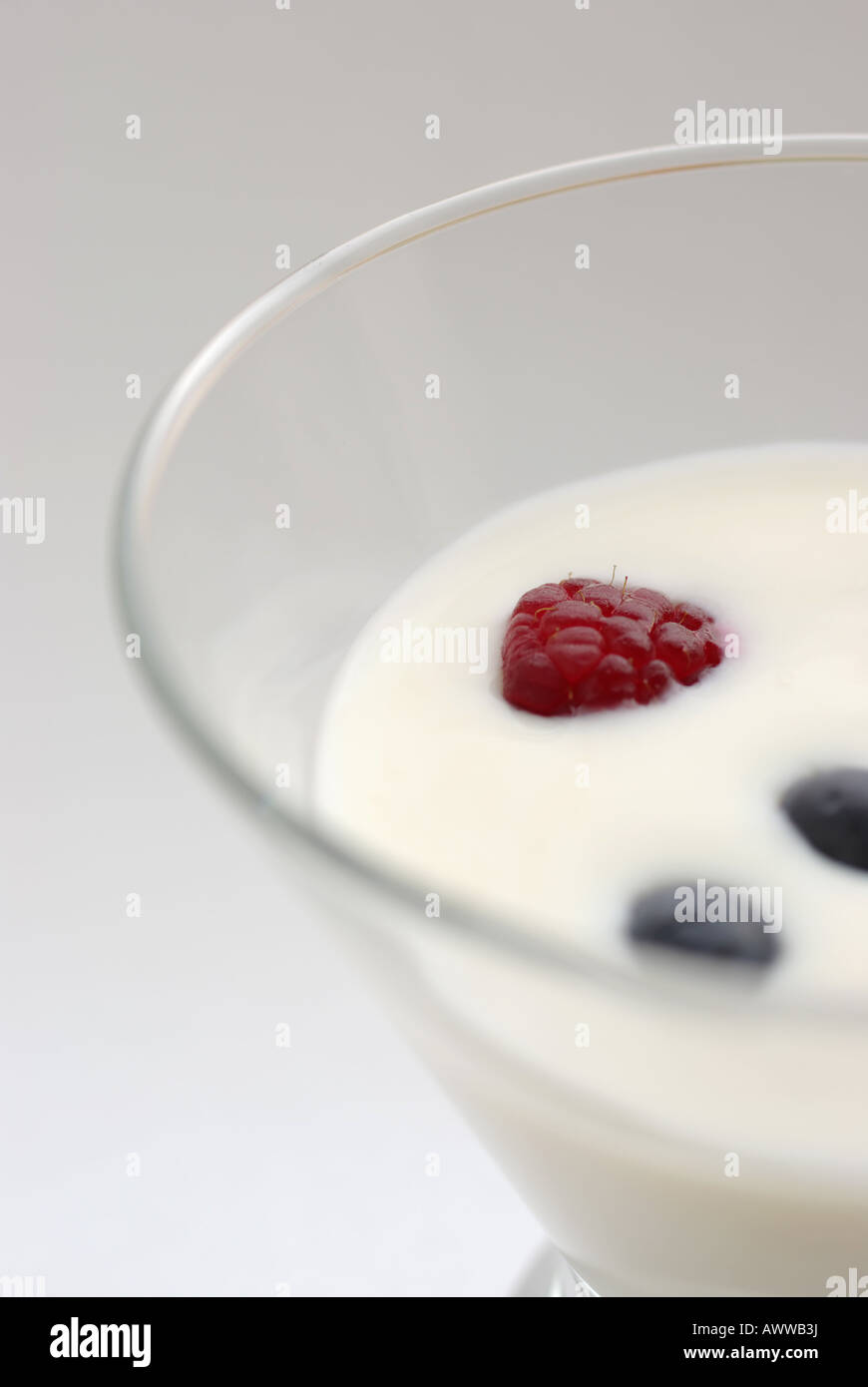 Raspberry and blueberries floating in yogurt Stock Photo - Alamy