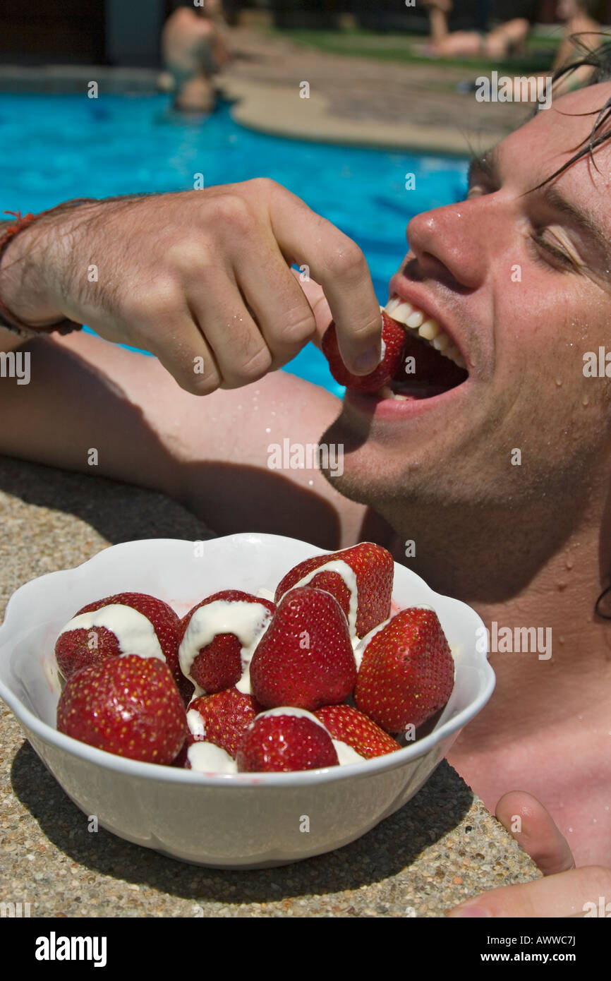 Man in Swimming Pool Eating Bowl of Strawberries and Cream Stock Photo ...