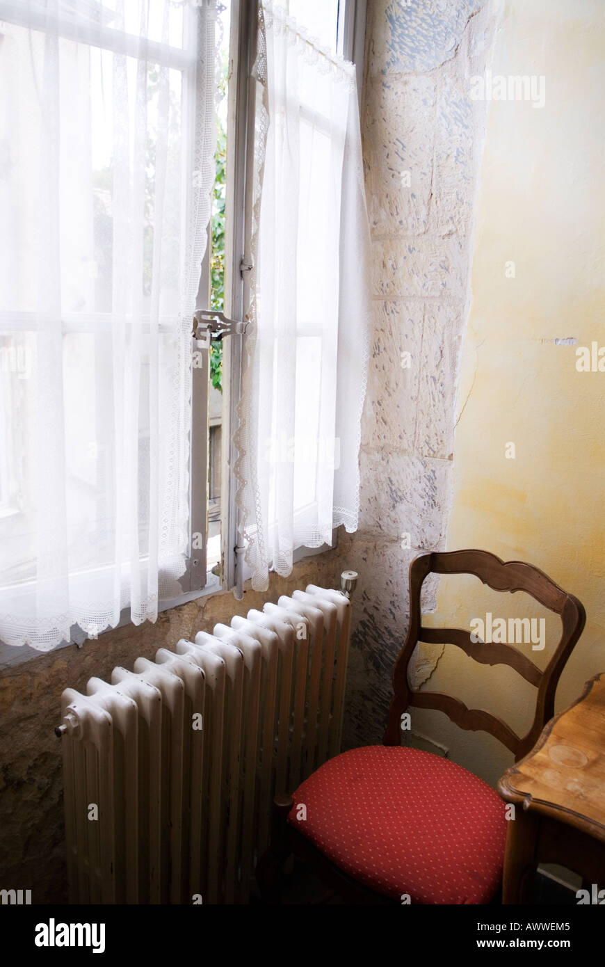 old fashioned empty chair in french room next to partially opened tall ...