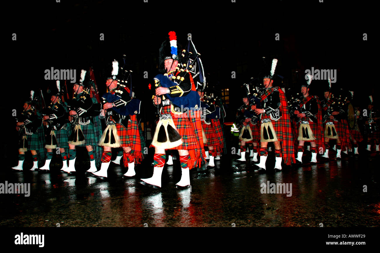 Pipe band marching in city centre after dark Stock Photo - Alamy