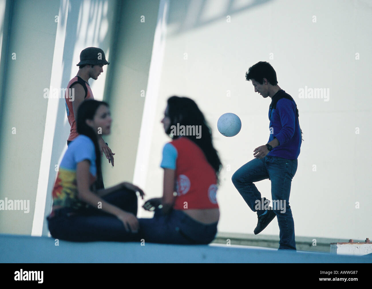 Two women talking in foreground, blurred, two men playing soccer Stock ...