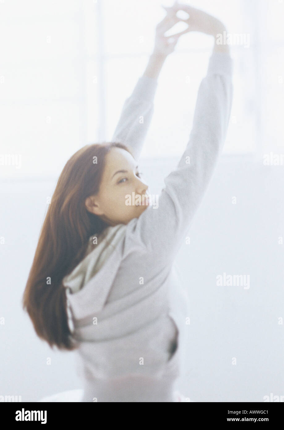 Woman stretching, looking over shoulder Stock Photo - Alamy