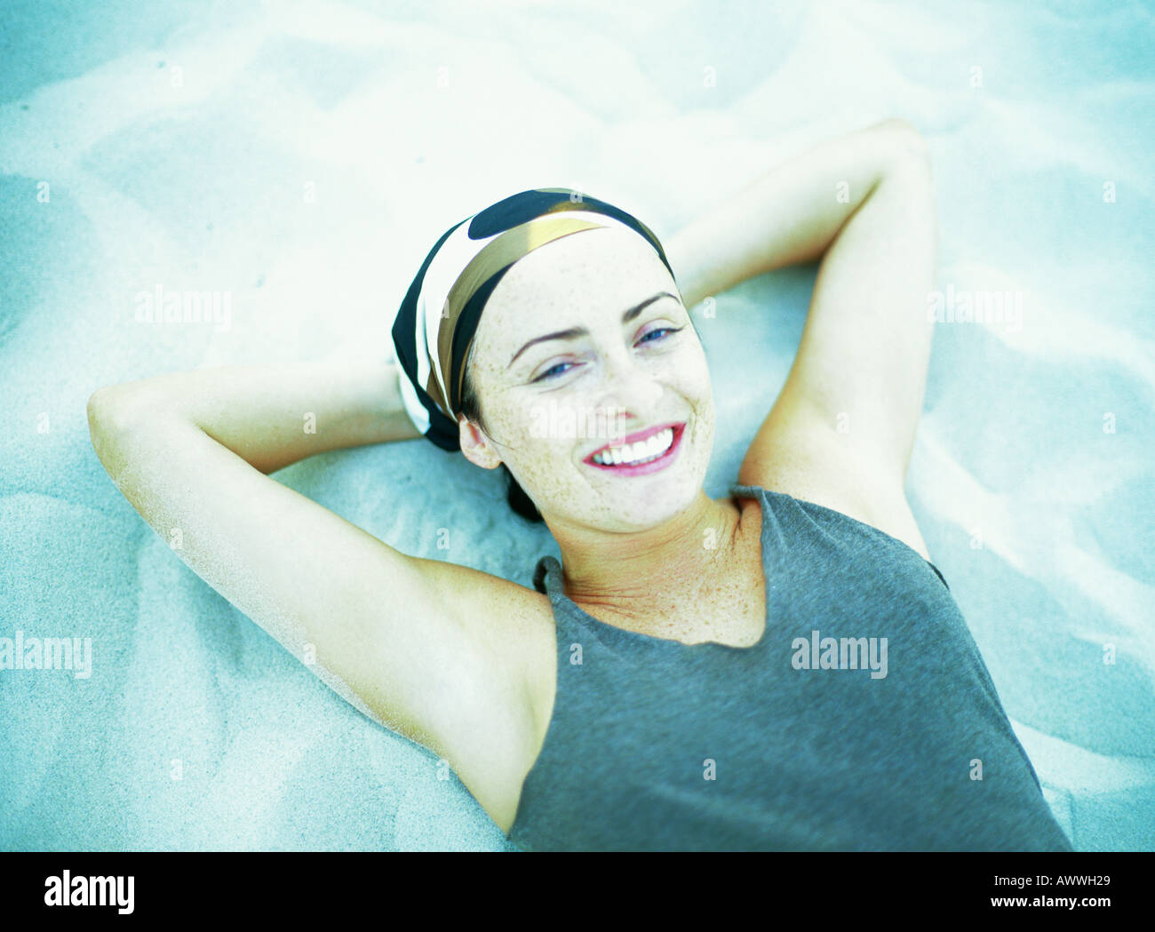 Portrait Smiling Woman Lying On The Beach Head Her Hands Hi Res Stock
